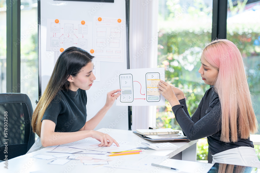 Two Young and beautiful creative female designer making a sketch while ...