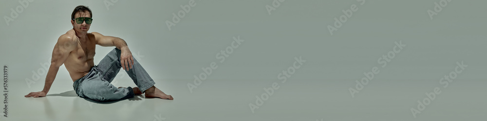 Foto Stock Handsome young man with strong muscular body shape sitting ...