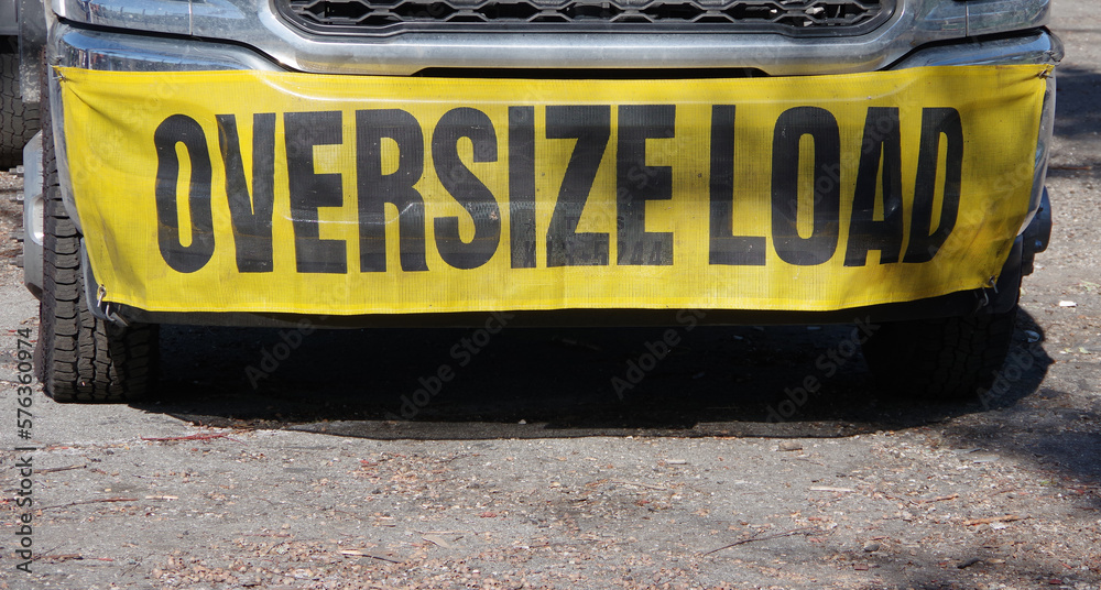 OVERSIZE LOAD warning banner on the front of a truck Photos | Adobe Stock