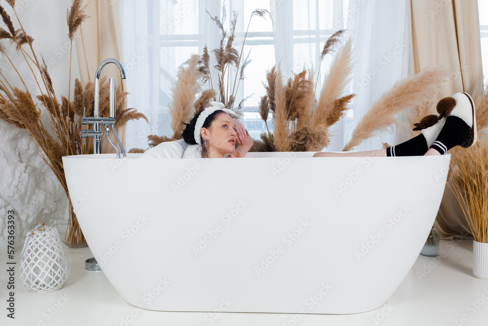 Attractive slim girl in a bathrobe with a bow on her head, wearing ...