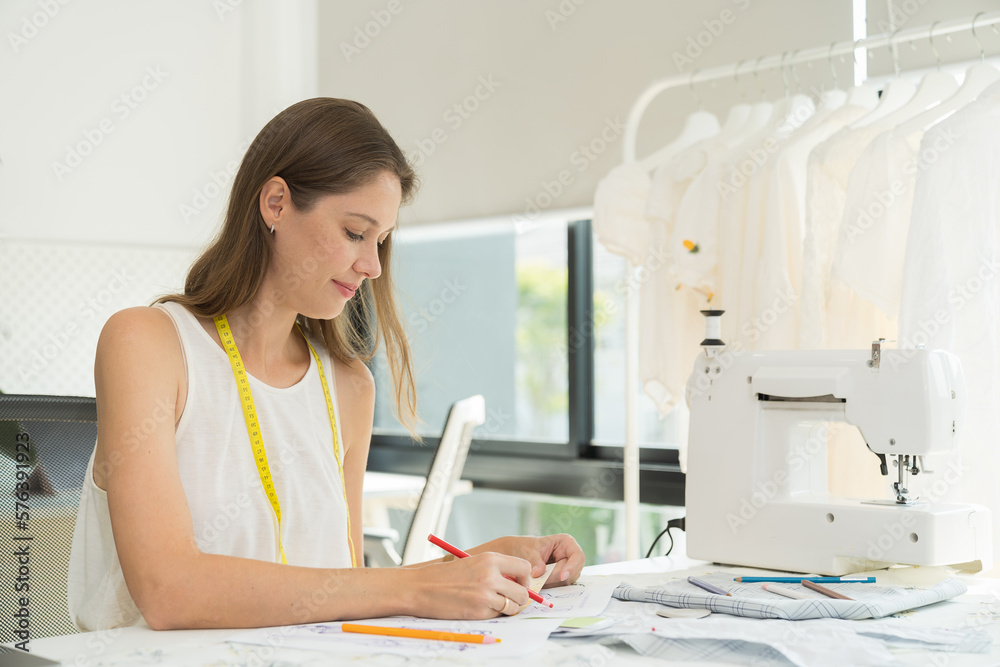 Female dressmaker working and choosing sample design sketch paper ...
