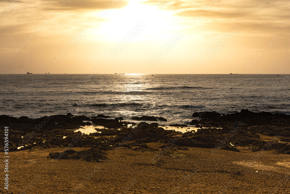 Sun front view, huge golden ball between clouds and sea at sunset beach ...