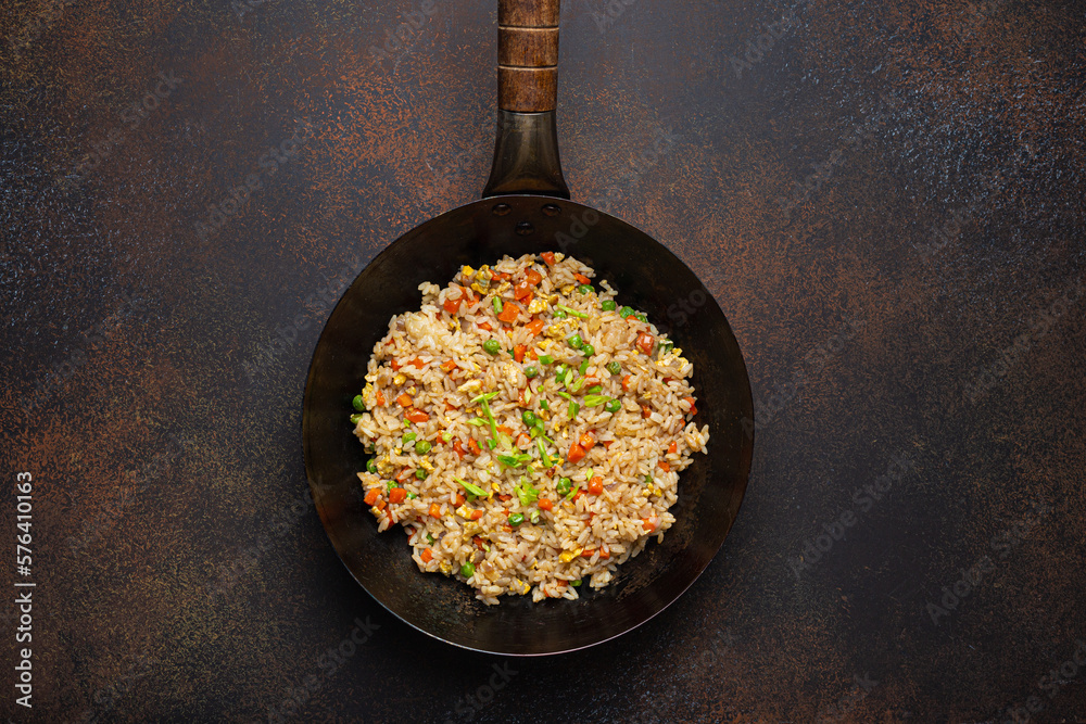 Authentic Chinese and Asian fried rice with egg and vegetables in wok ...