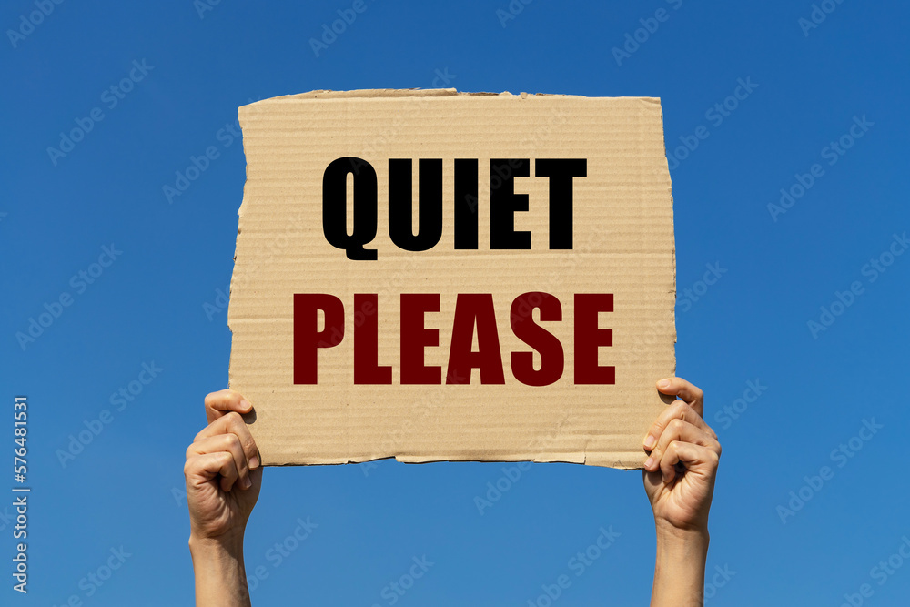 Quiet please text on box paper held by 2 hands with isolated blue sky ...