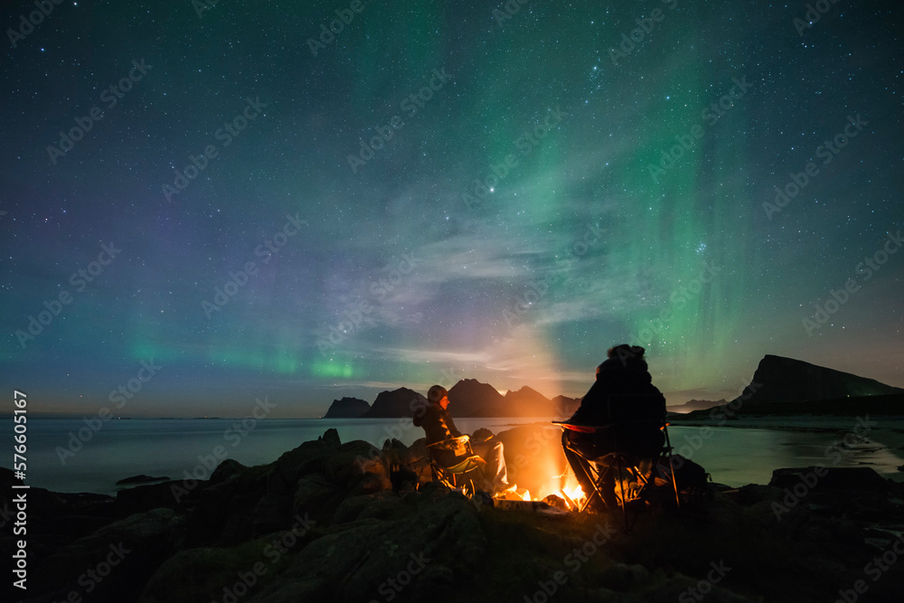 Sitting around an campfire with northern lights - aurora borealis in ...