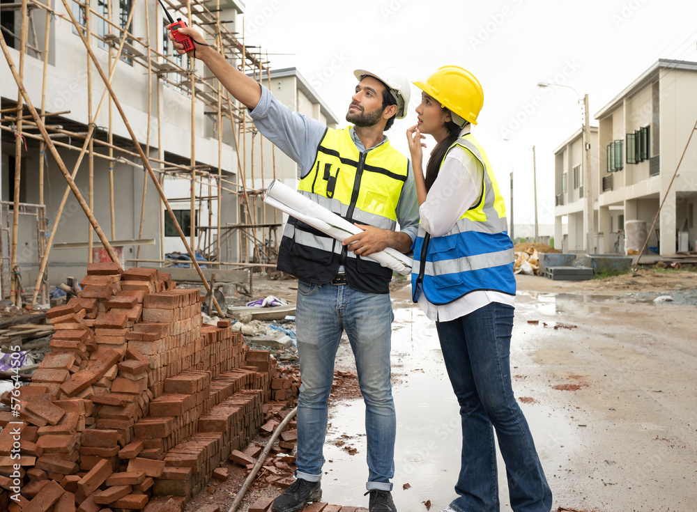 Engineer man and female architect wear safety helmets discuss housing ...