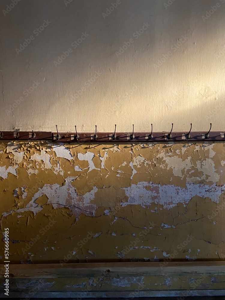 Old school classroom coat hanger on rustic wall with peeled painting ...