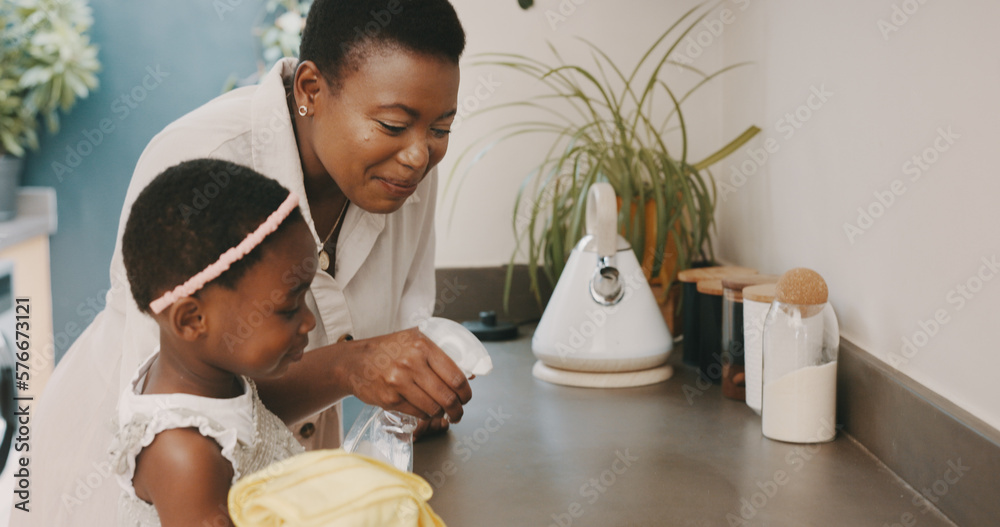 Little girl helping her mother with household chores at home. Happy mom ...