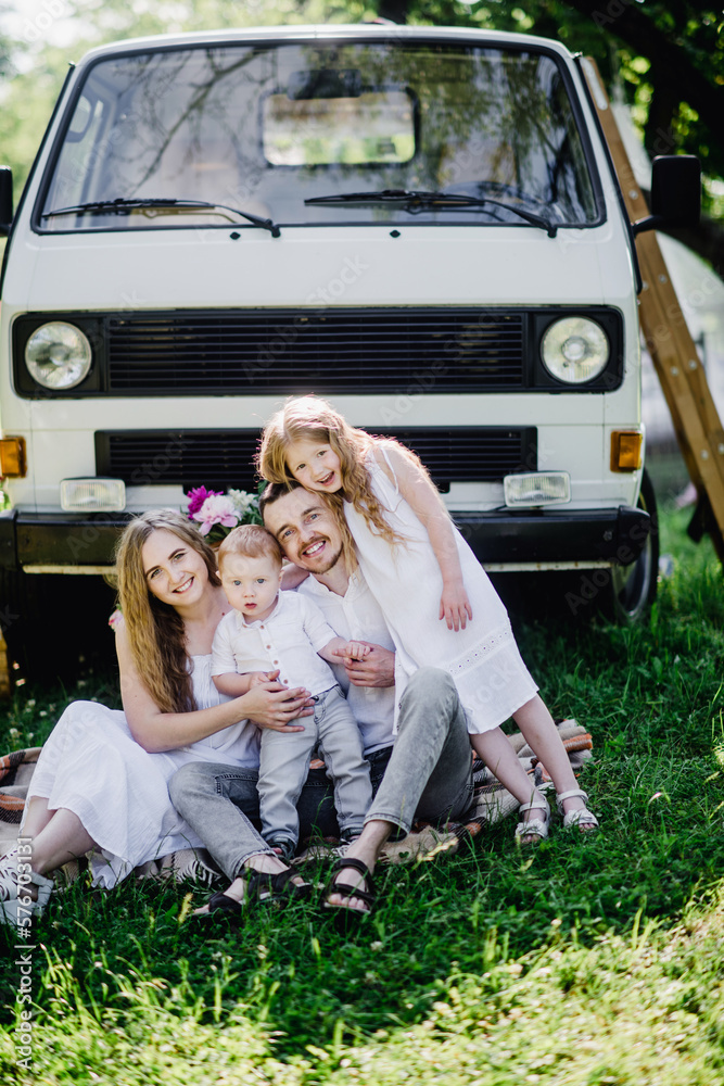 bright smiling family with two kids in a front of a house on wheels ...