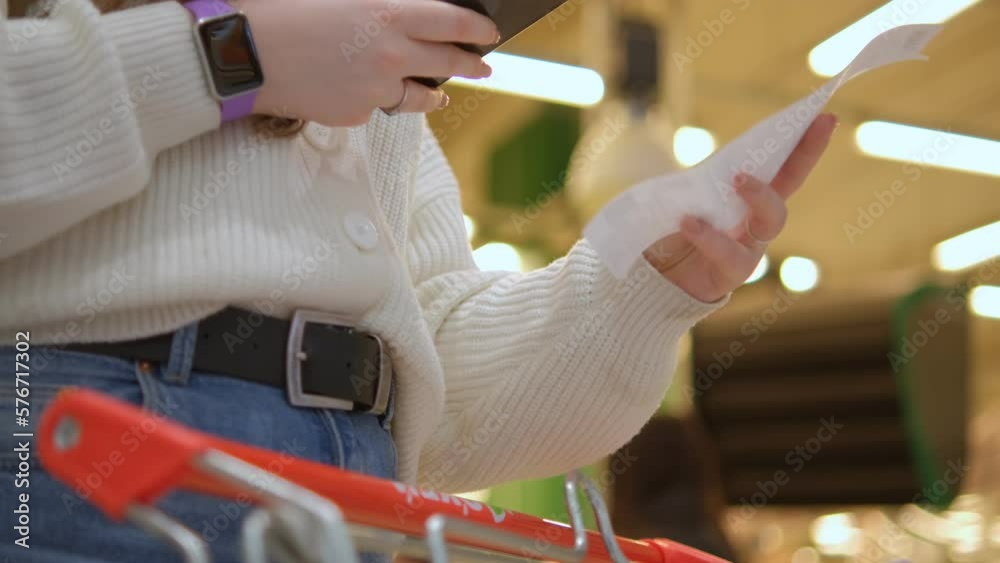 Woman hands holding paper receipt. Woman housewife looking check after ...