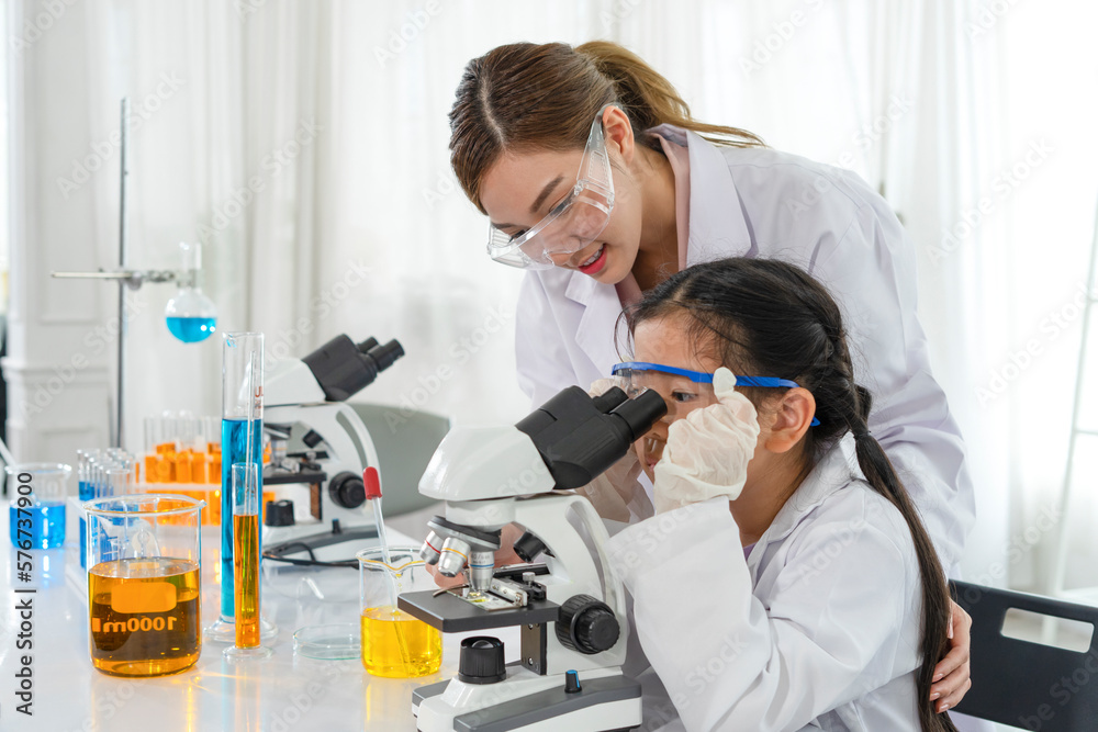 female scientist as a mentor is teaching the students, kid studying ...