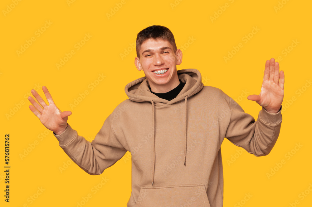 Handsome young wide smiling man is holding arms wide open to welcome ...