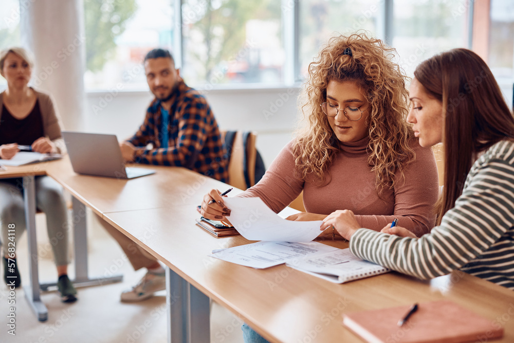 College student and her female classmate studying in classroom. Stock ...