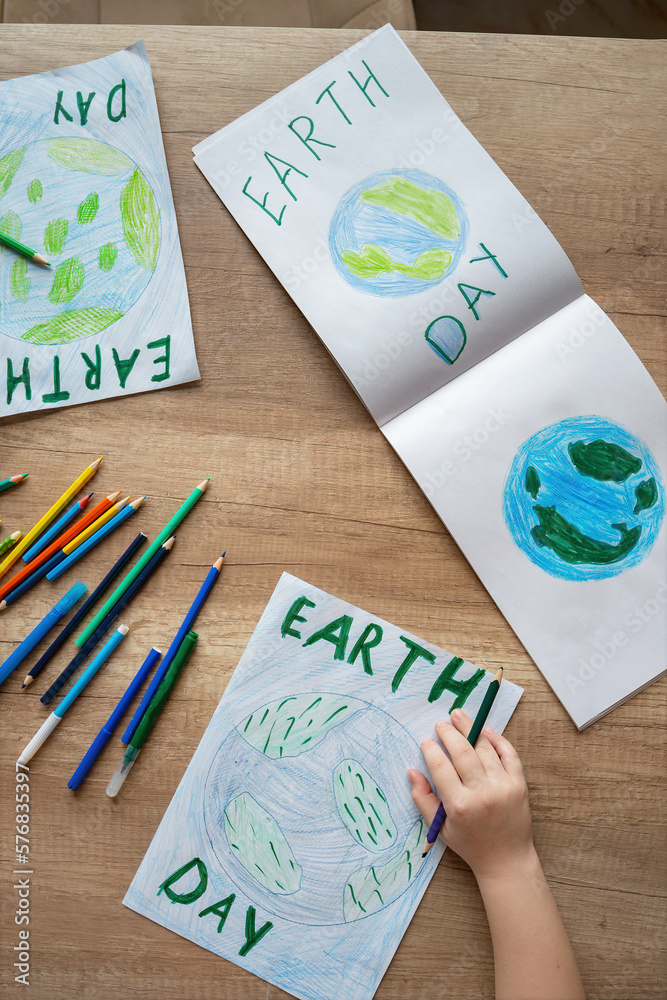 Foto de A child at school at the table draws the planet Earth with a ...