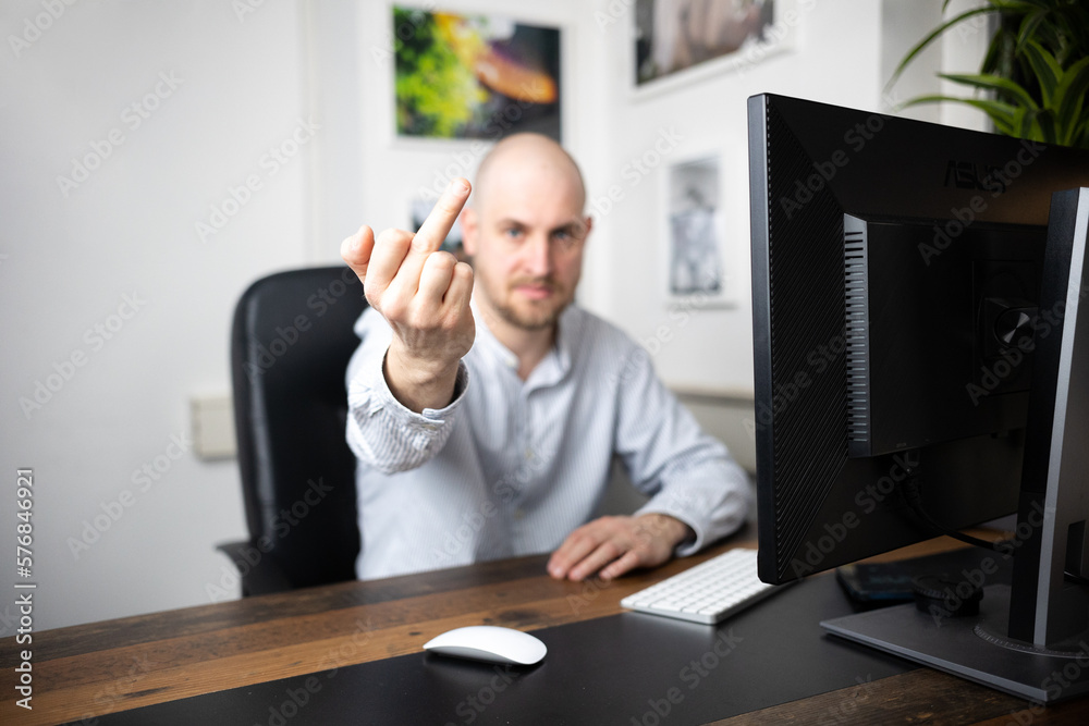 Angry employee shows middle finger in his office/home office after ...