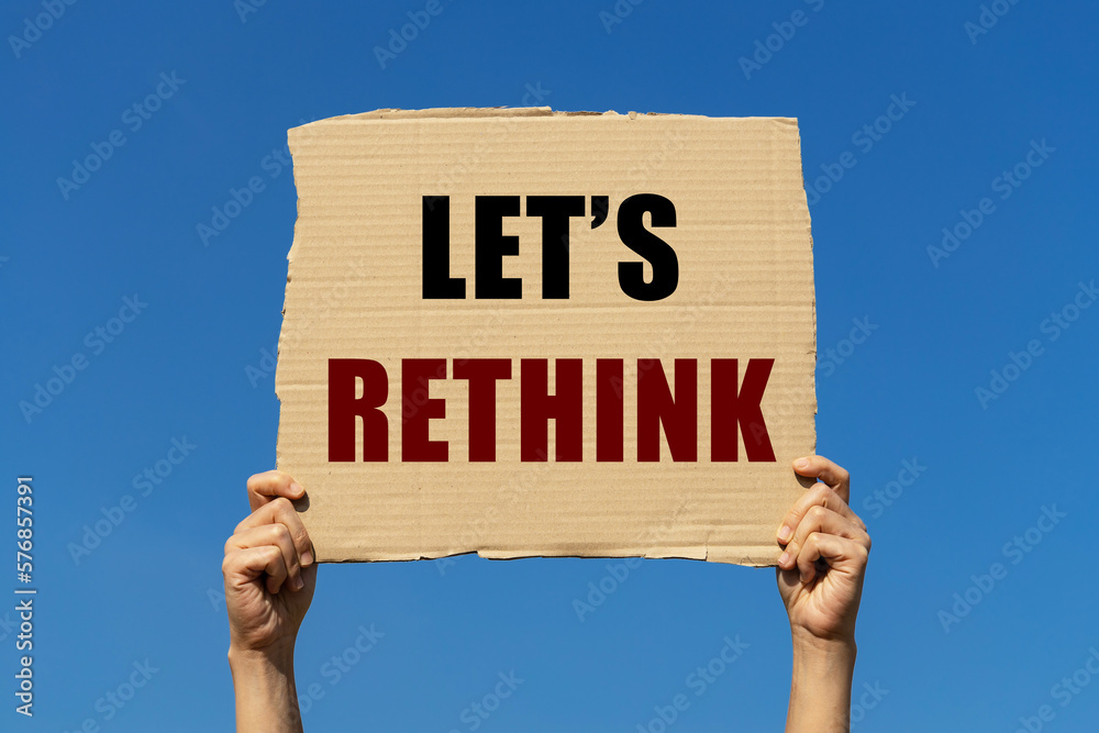 Let's rethink text on box paper held by 2 hands with isolated blue sky ...