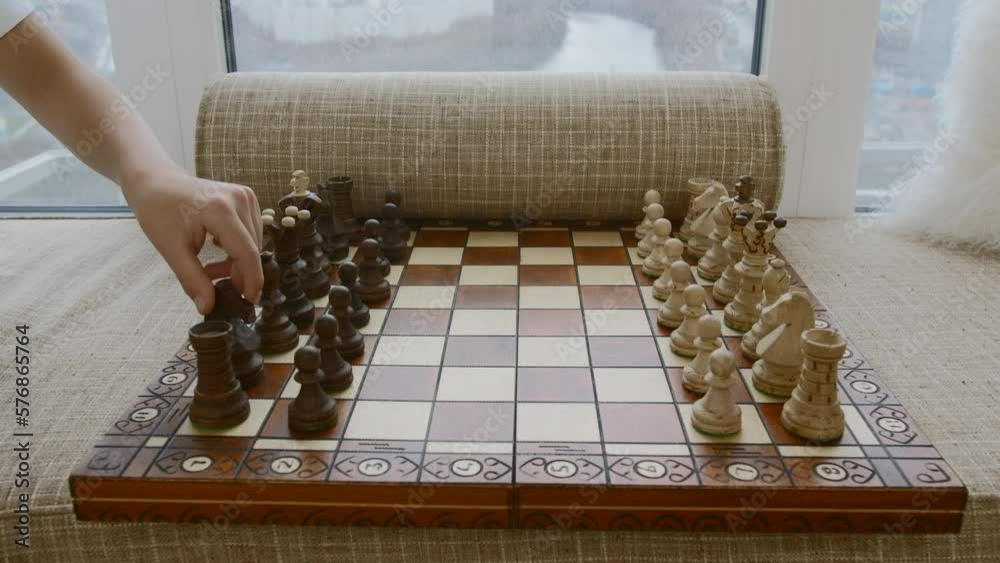Child's hand makes chess move. Creative. Expensive chess board with ...