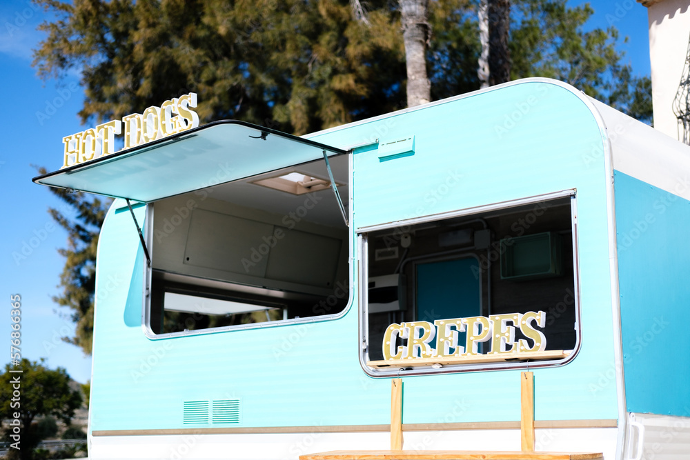 Blue and white caravan transformed into food truck with hot dog and ...