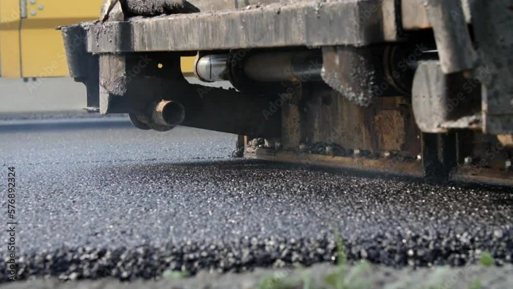 Road paving machine stacking asphalt road construction site on the ...