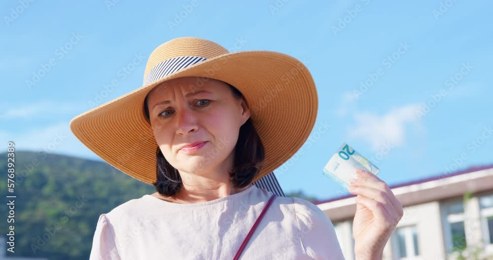 Woman straw hat against backdrop of mountains sky holds bill of money ...