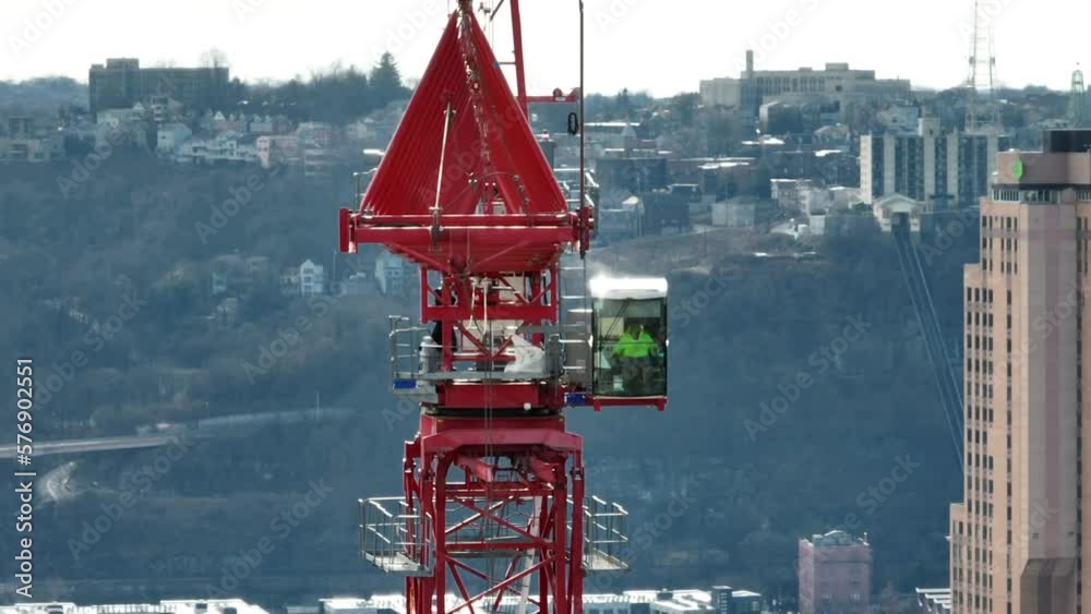 Tower crane turning through static aerial shot with long zoom. City ...