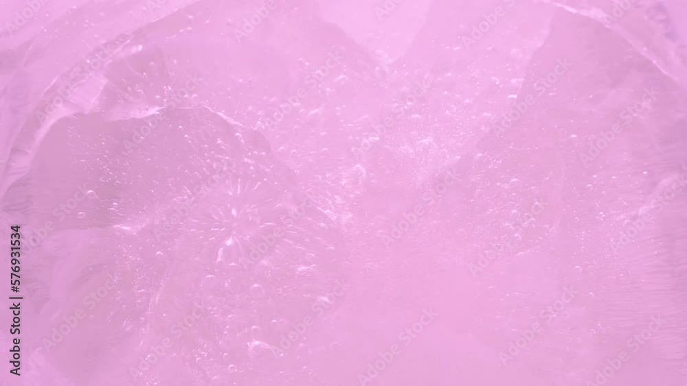 Macro pink broken ice texture with splashing water surface, drops and ...