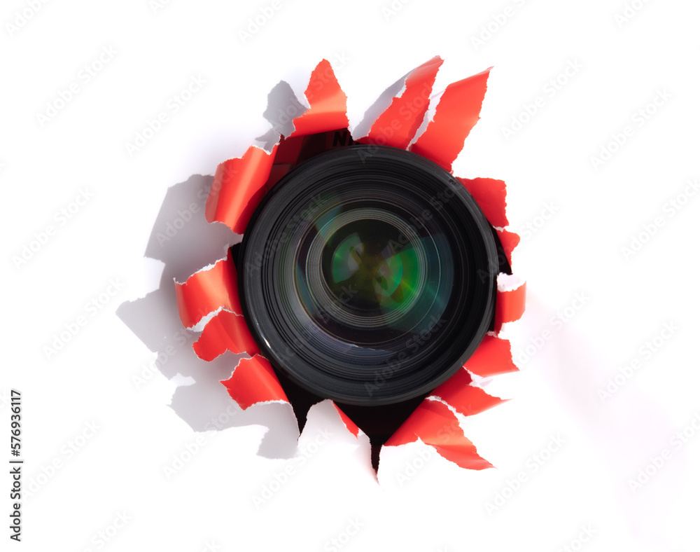 Hidden camera lens through hole in white paper,Concept of paparazzi or ...