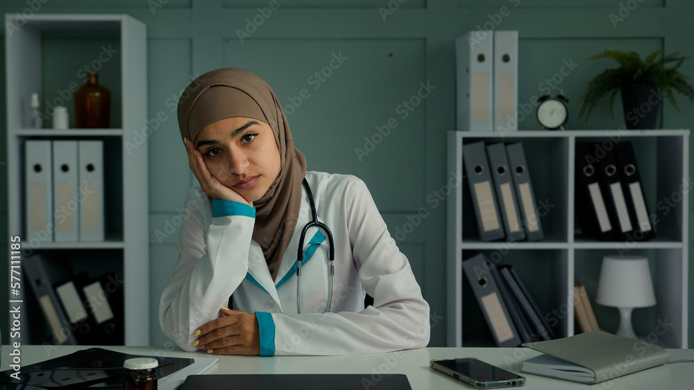 Bored unhappy thoughtful woman muslim doctor intern sit at office ...