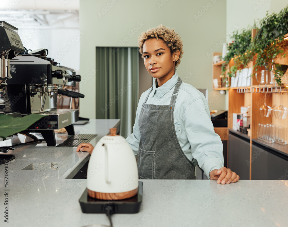 Young barista in a coffee shop. Young female with short hair working as ...