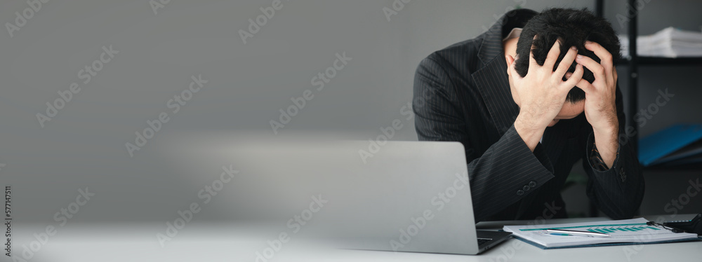 Businessman sitting in a company office, he is holding his head having ...
