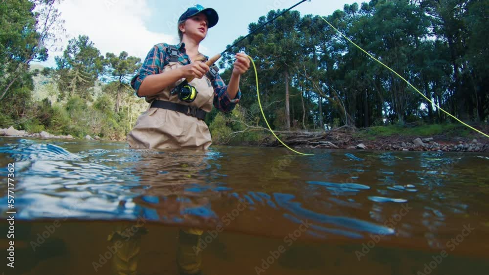 Angler in the river underwater view. Pretty woman angler wearing casual ...