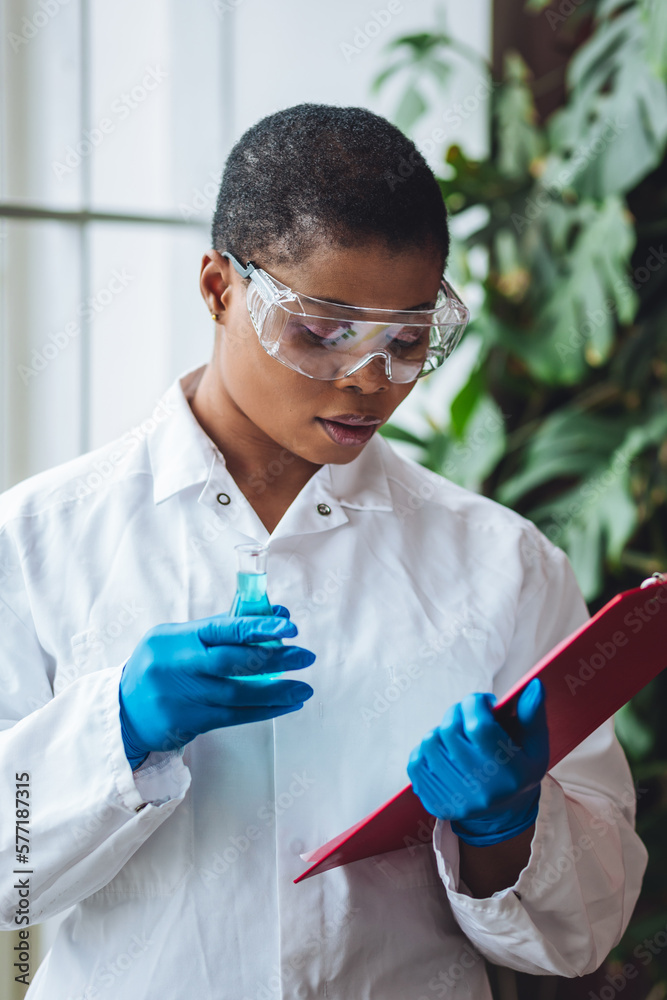 African American female scientist is working in laboratory, making test ...