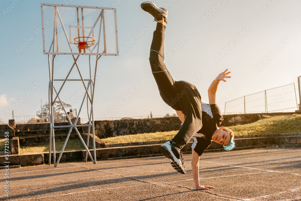 teenager boy dancing breakdance on a basketball court. hip hop culture ...
