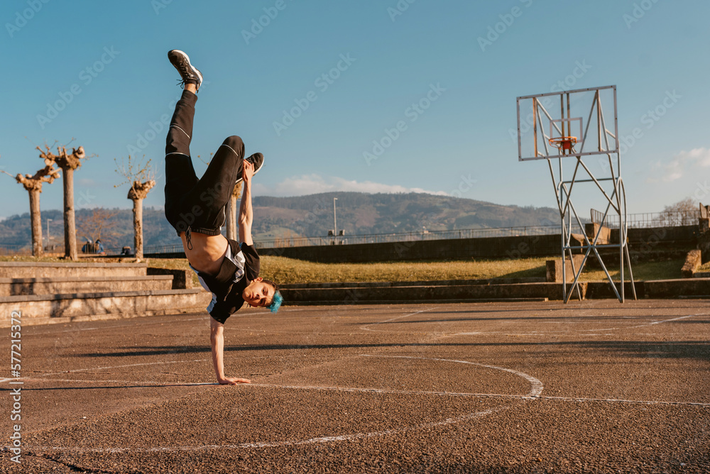 teenager boy dancing breakdance on a basketball court. hip hop culture ...