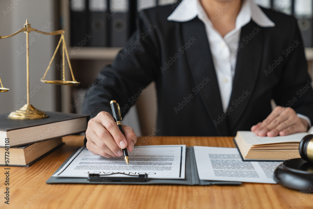 Asian female legal advisor or a lawyer using a pen to check business ...