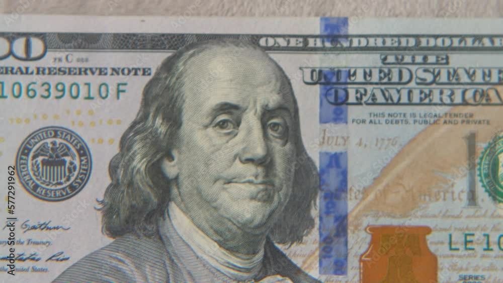 close-up with a magnifying glass examine 100 dollar bill,selective ...