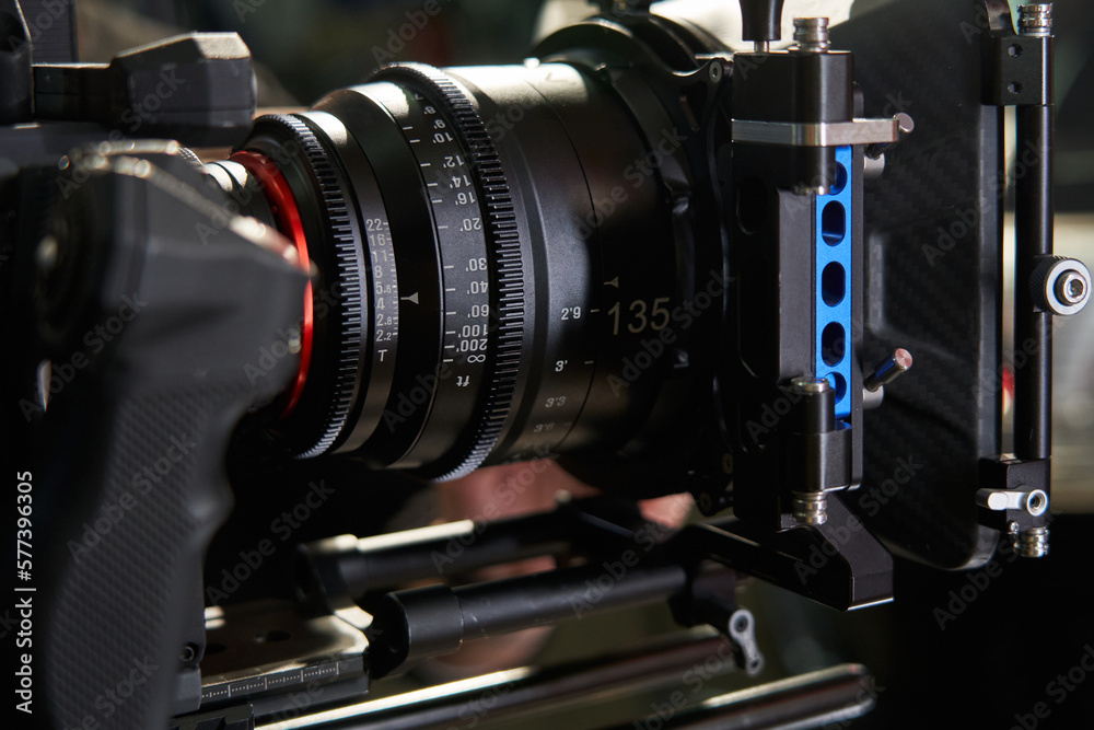 professional 135 mm lens mounted on a movie camera with a full body kit ...
