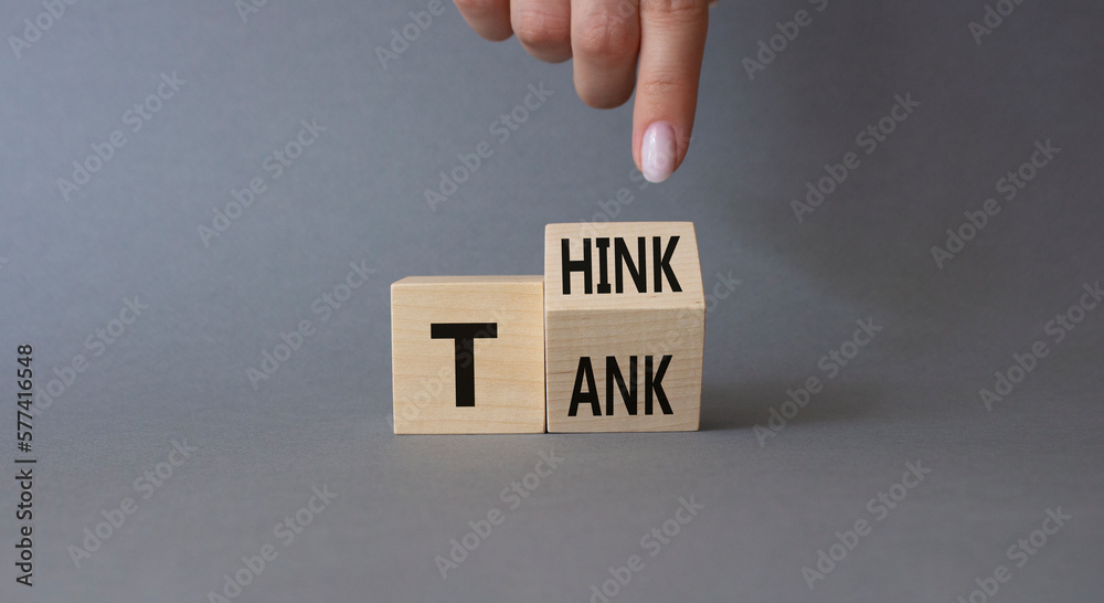 Think Tank symbol. Businessman hand points at turned wooden cubes with ...