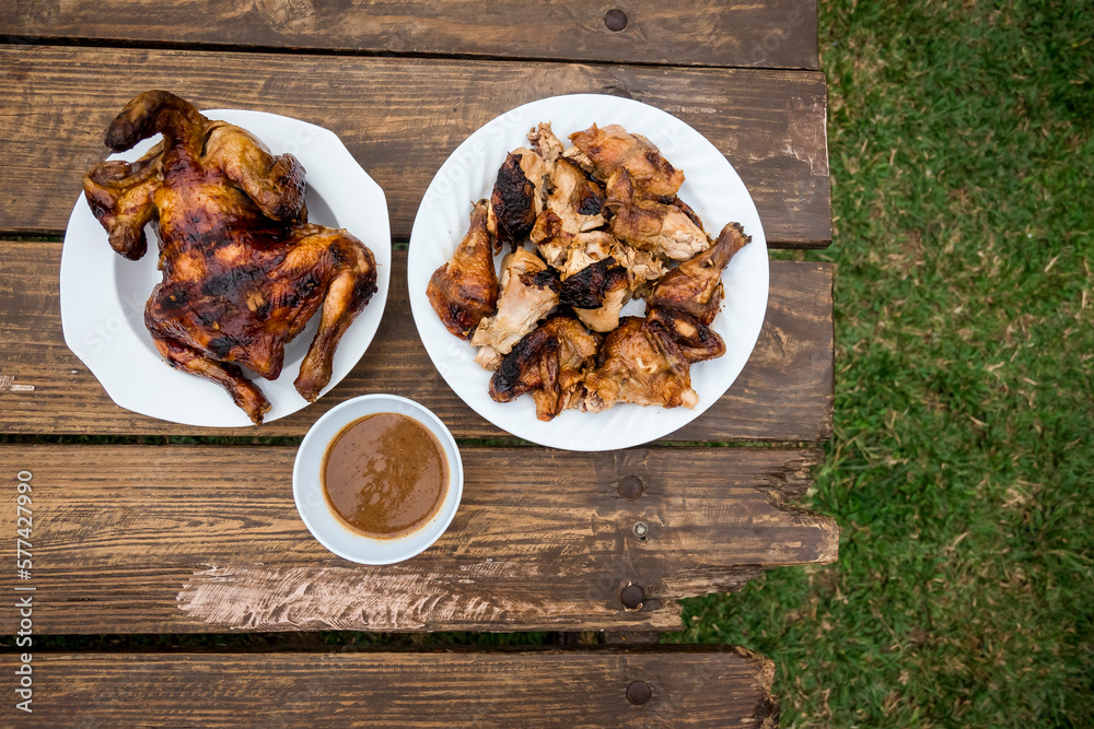 Lechon Manok, or roasted chicken served both whole and chopped outside ...