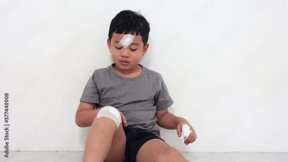 Asian boy is sad He had wound on face and fingers. Asian kid boy was ...