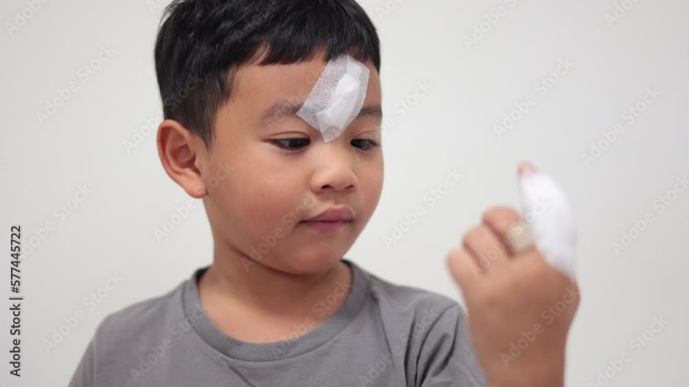 Asian boy is sad He had wound on face and fingers. Asian kid boy was ...