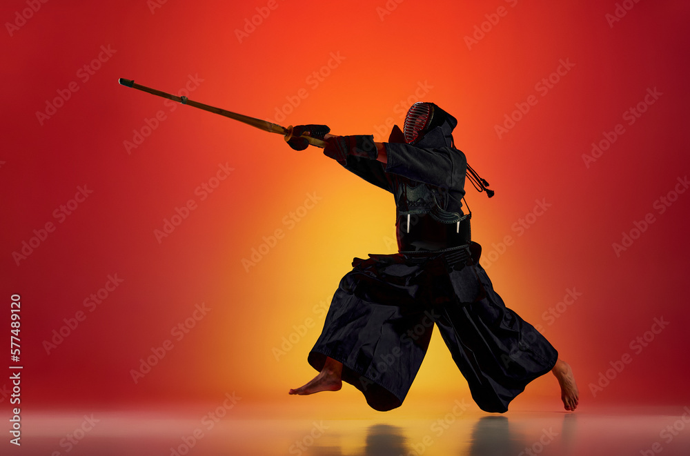 Man, professional kendo athlete in black uniform with sword, shinai ...
