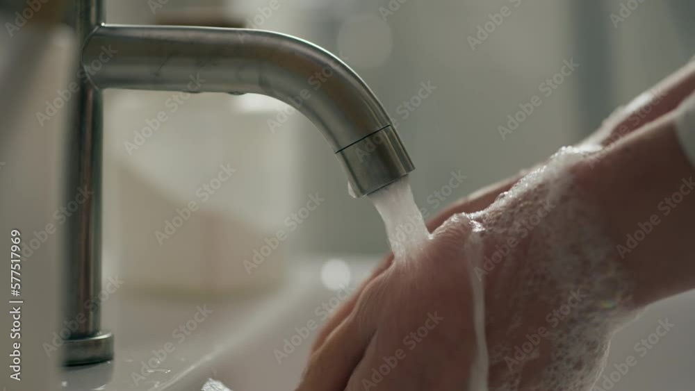 A teenage girl cleanses her hands of germs and bacteria by washing them ...