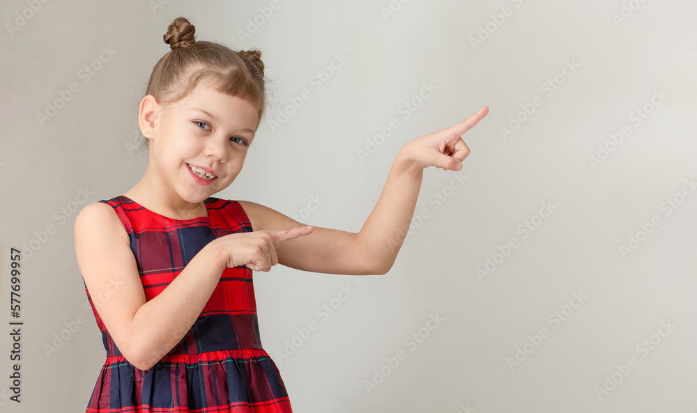 Smiling child showing on copy space by index finger on both hands ...
