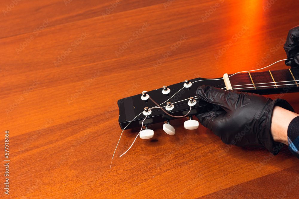 man with guitar, master hand tuner in gloves with classical guitar ...