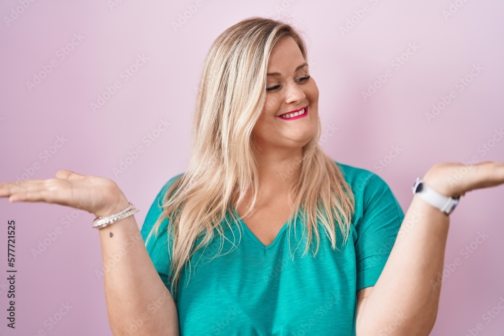 Caucasian plus size woman standing over pink background smiling showing ...
