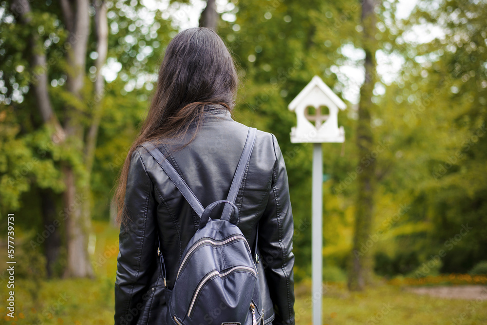 girl walks in an spring park, young lady back view. woman in black ...