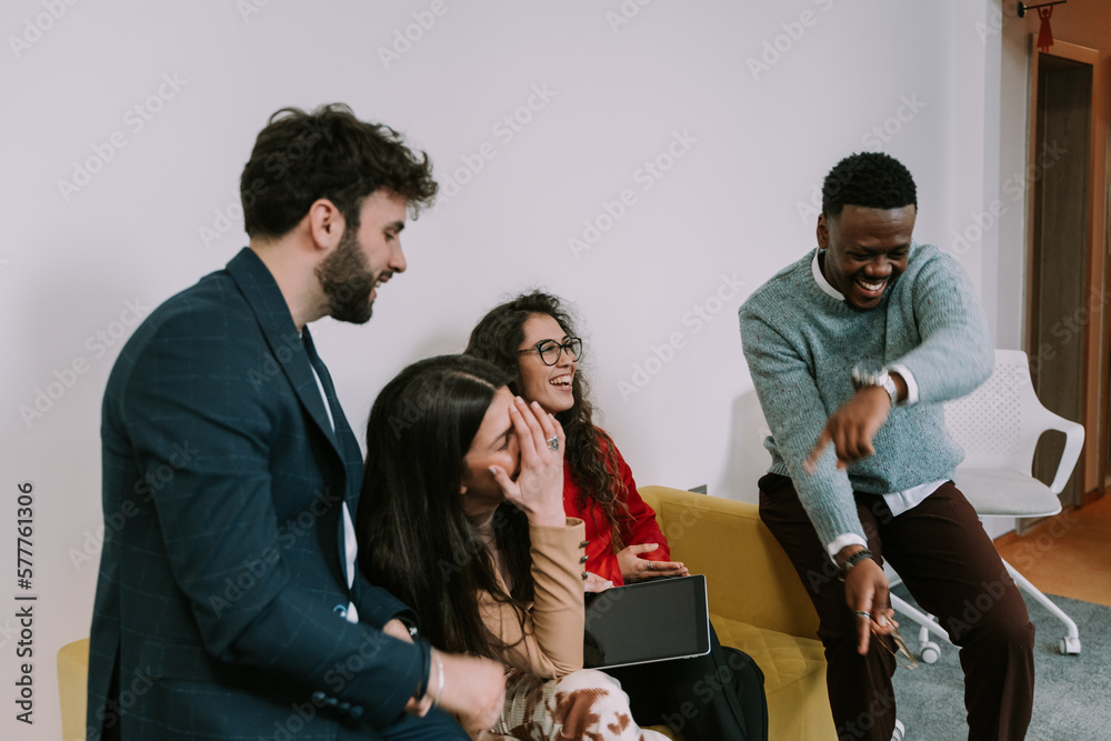 Multiracial colleagues burst out laughing after joking each other while ...
