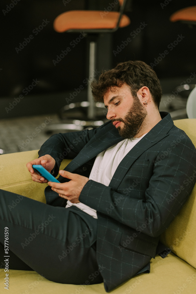 Good looking male business person lying on yellow sofa at modern co ...