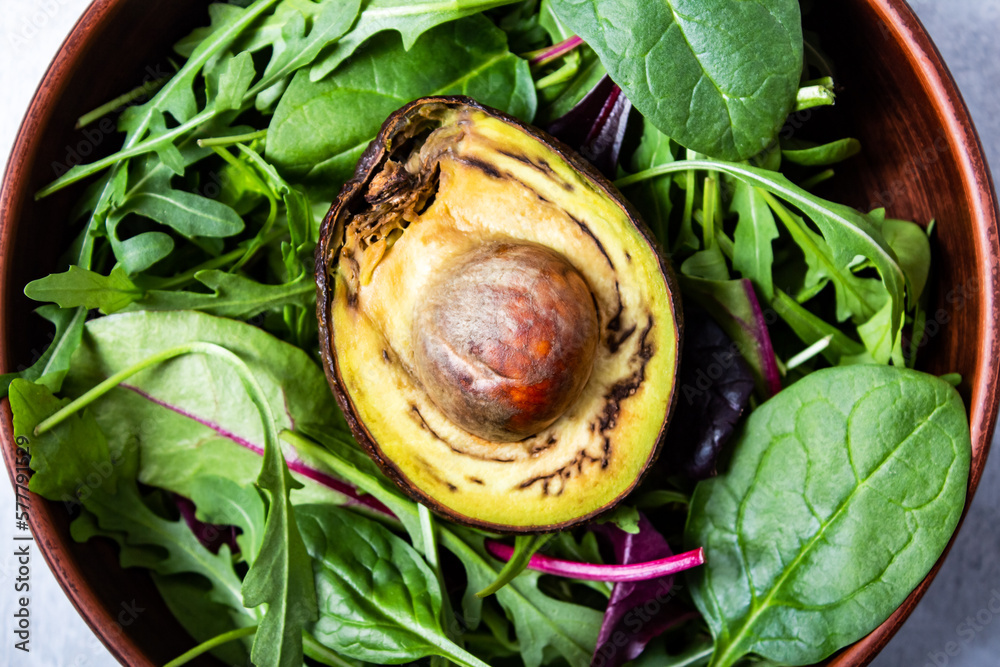 Rotten avocado, overriped, bad avocado. Half sliced fruit in a bowl of ...